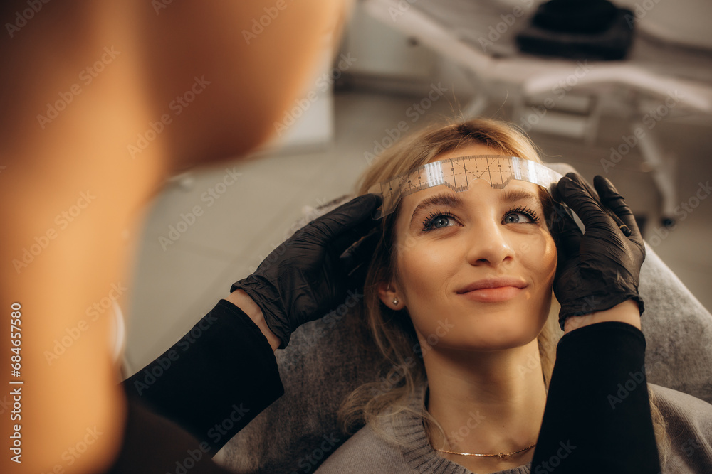 Marking of eyebrows. Permanent brow makeup. Markings with white paste ...