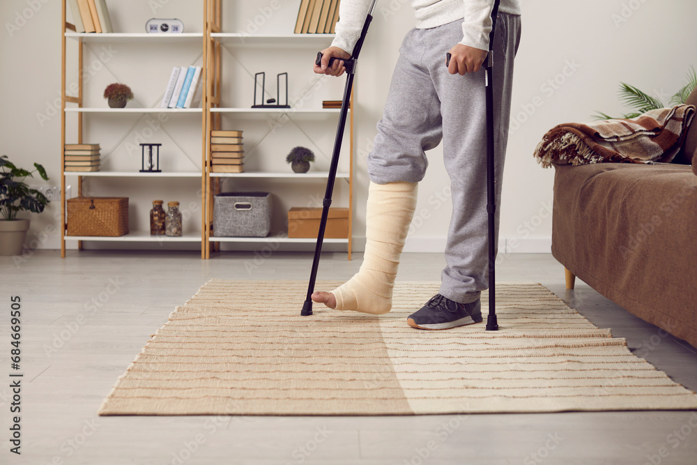 Cropped photo of a handicapped man with broken leg trying to walk using ...