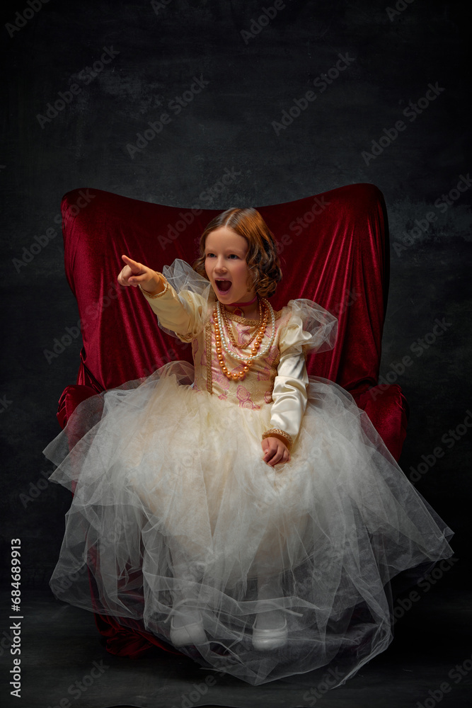 Get out. Little girl sitting on throne wearing in old-fashioned dress ...