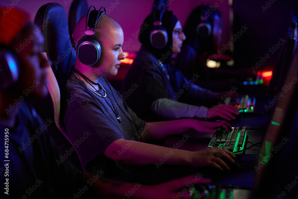 Side view portrait of gen Z young woman playing video games in ...