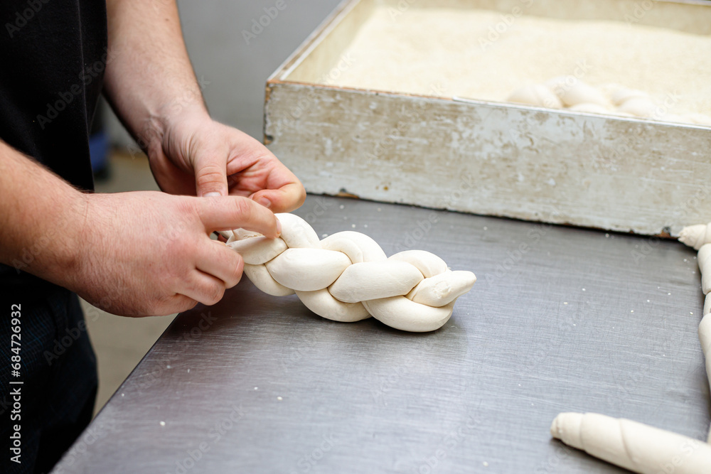 Making braided bread in a bakery. Traditional Shabbat challah Stock ...