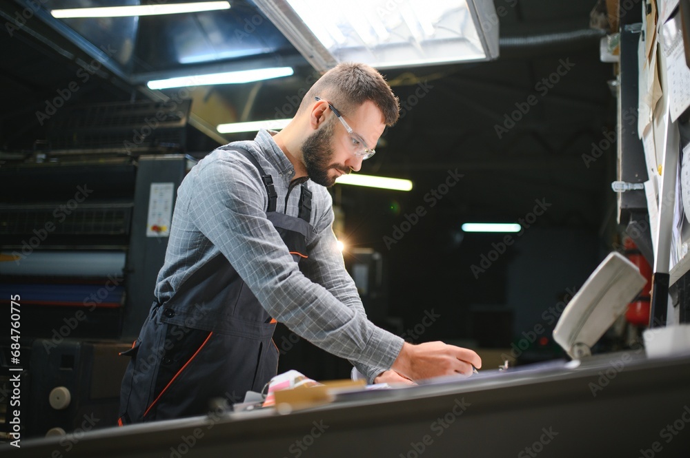 Printing house interior with modern offset print machine and operator ...