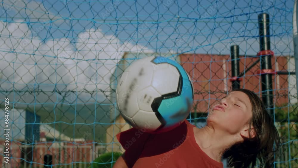Junior player in soccer uniform blocks ball with shoulder. Boy stands ...