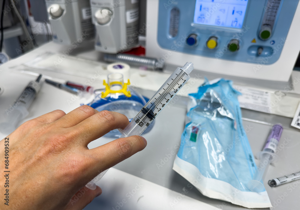 medications, syringes, vials, and monitoring equipment, depict ...