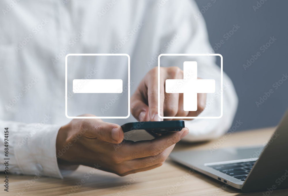 using a smartphone shows icons plus and minus. sign opposite negative ...