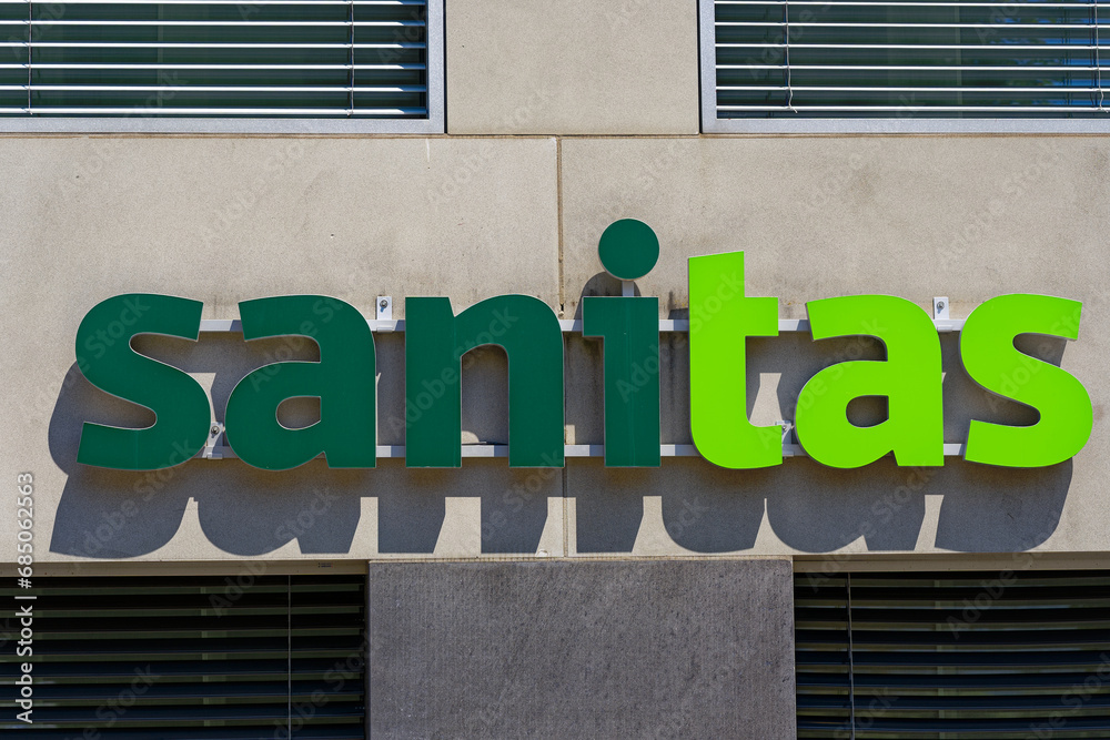 Green logo of Swiss health insurance company Sanitas outside of office ...