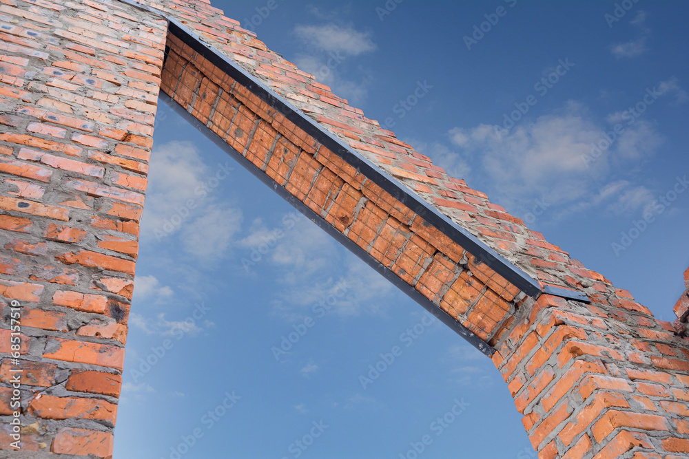 Window, door metal lintel with iron bar on brick unfinished building ...