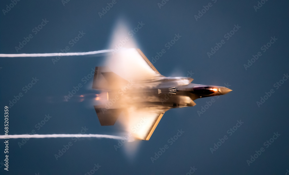 Modern American military stealth fighter jet in flight with vapor ...
