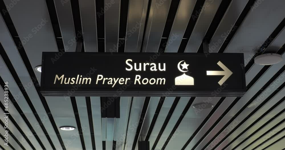 Directional sign to Muslim Prayer Room under ceiling at modern airport ...