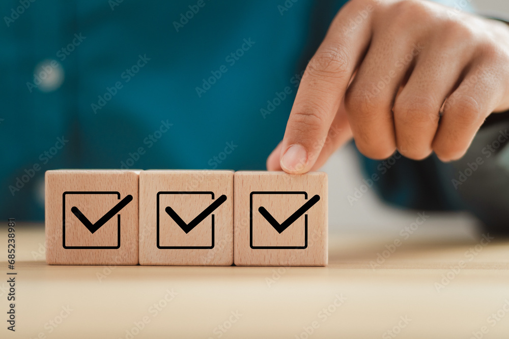 Checklist survey concept. Man hand putting wooden cube with checklist ...