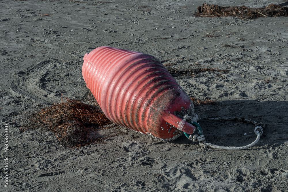 Red buoy stranded on the beach. Red buoy stranded after a violent storm ...