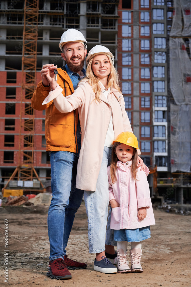 Full length of man holding apartment keys and smiling while standing ...