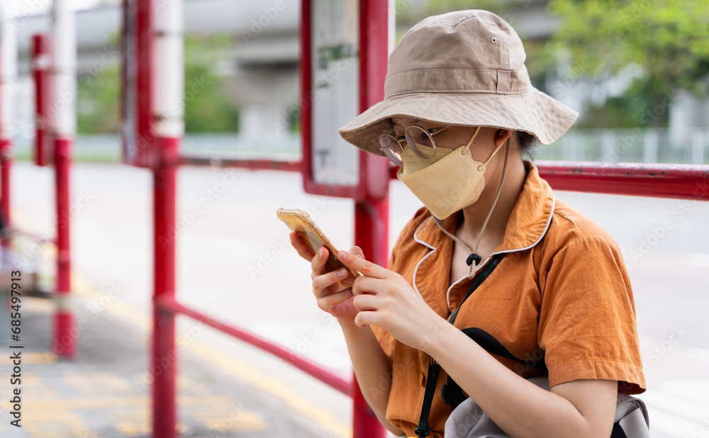 Female tourists are waiting for public transport and browse or search ...