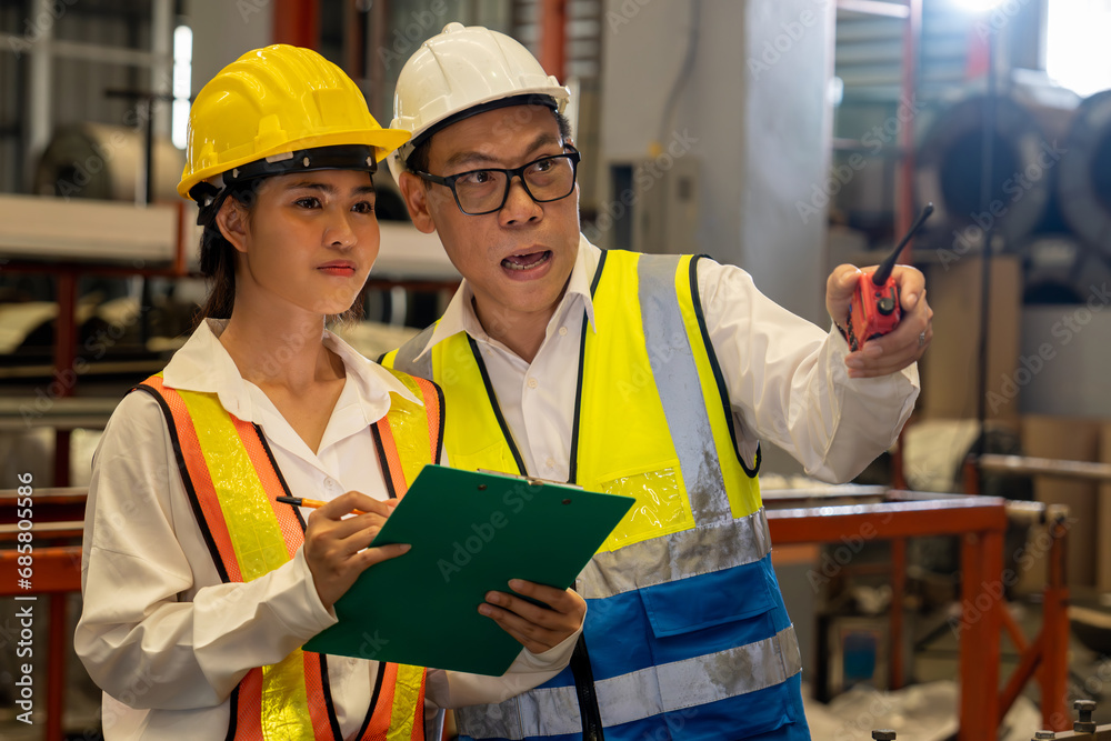 Factory foreman worker and engineer conduct inspection of industrial ...