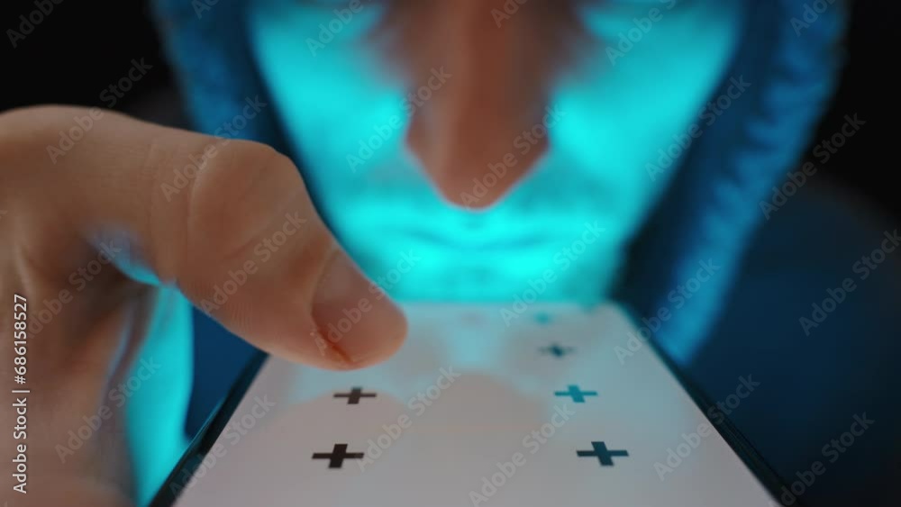 Blue light illuminates the face of the man who is browsing something on ...