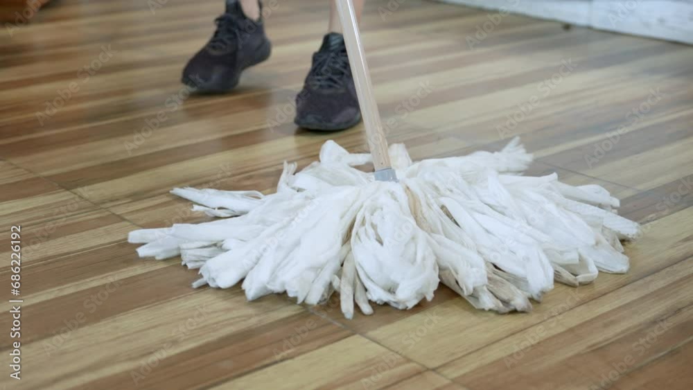 Pretty Asian lady waiter sweeping, mopping the coffee shop floor with a ...