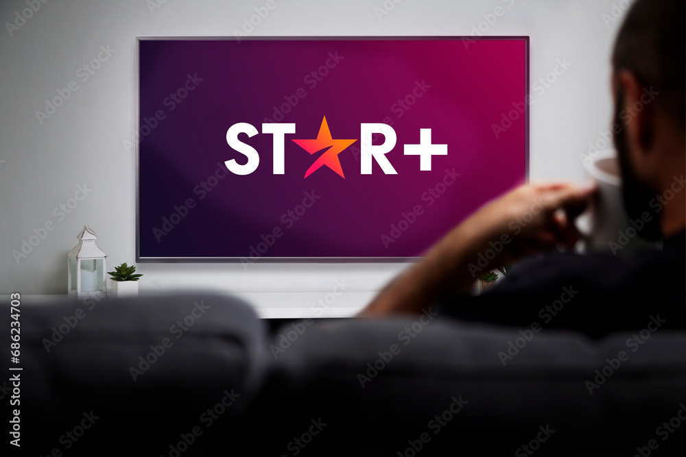 Star Plus on smart TV. Man with a mug and watching television with a ...