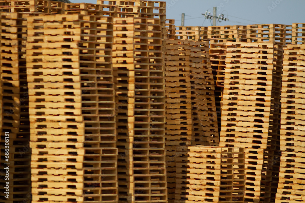 multiple wooden columns of shipping pallets piled high in an outdoor ...