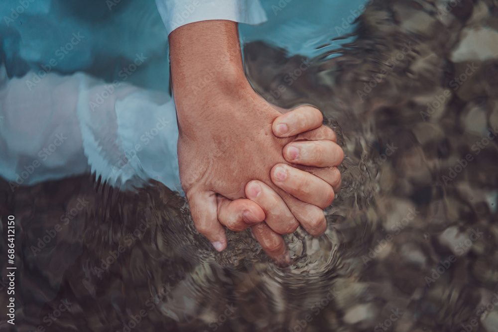 Close up photo the hands of a romantic couple are intimately entwined ...