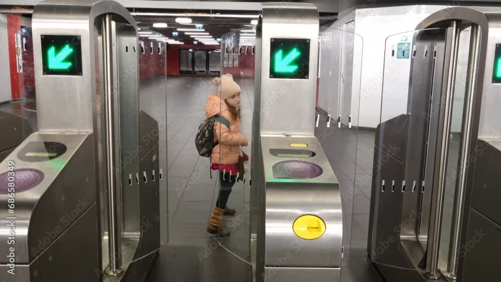 Child little girl passing her ticket in an automatic door in a subway ...
