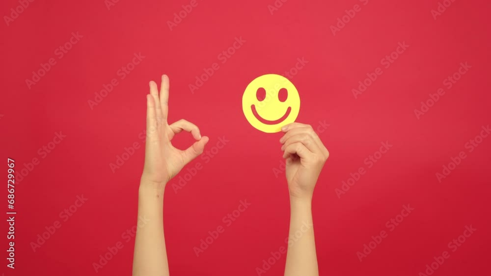 Female hand holding yellow happy smile emoticon, good feedback rating ...