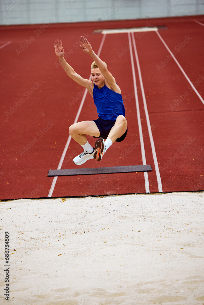 Determination evident in running long jump. Athletic man, sportsman ...