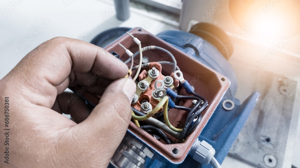 an Electrician Connecting the cable terminals power induction three ...