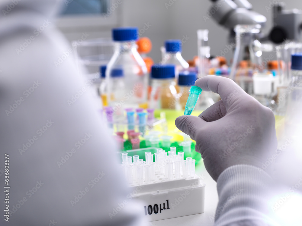 Biotechnology Research, Scientist viewing specimens in a vial during an ...