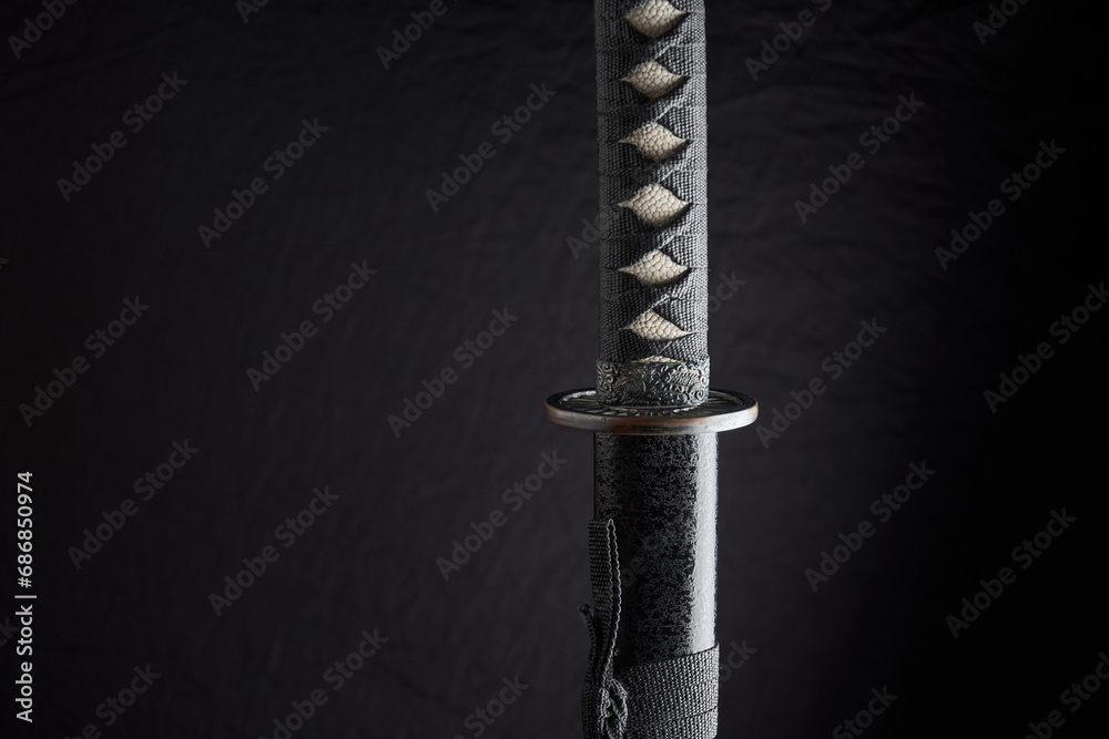 Horizontal photo of sheathed katana with details of the handle and ...