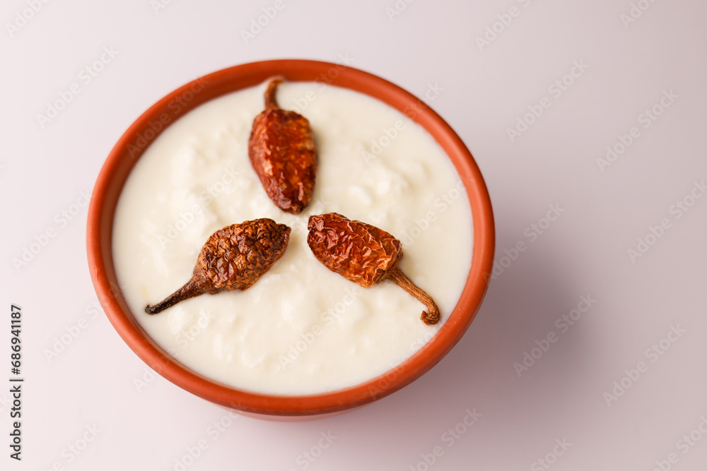 Bowl of homemade sour cream curd yogurt Dahi fresh herbs curry leaf ...