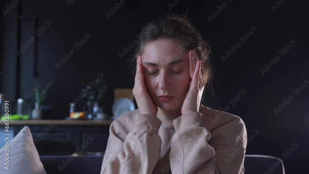 Pretty girl holds her head with her hands and rubs her temples. Woman ...