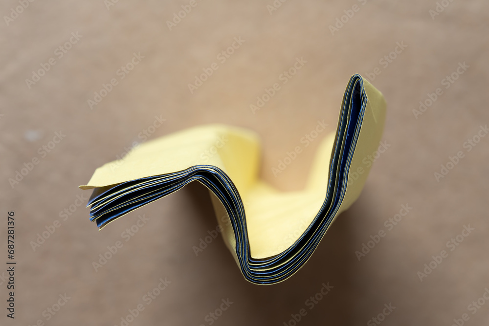 yellow and blue construction paper sheets partly crumpled and folded ...