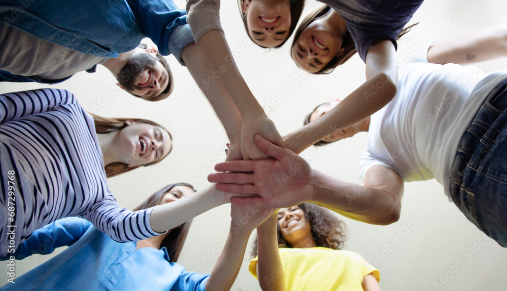 Down view on hands together. Group of happy modern people at work ...