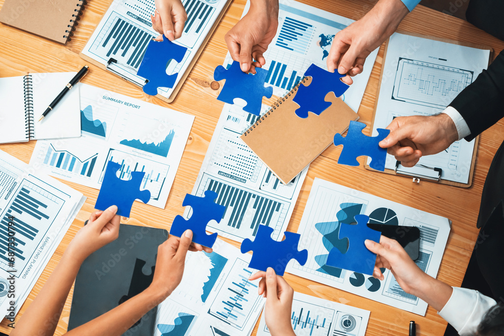 Multiethnic business people holding jigsaw pieces and merge them ...