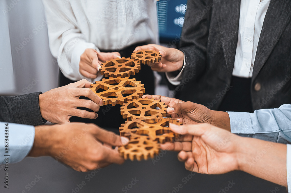 Office worker holding cog wheel as unity and teamwork in corporate ...