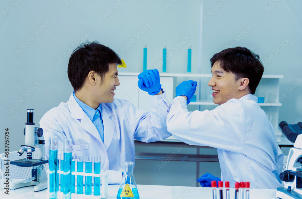 Two asian scientist men fist bump team partner shake hands together ...