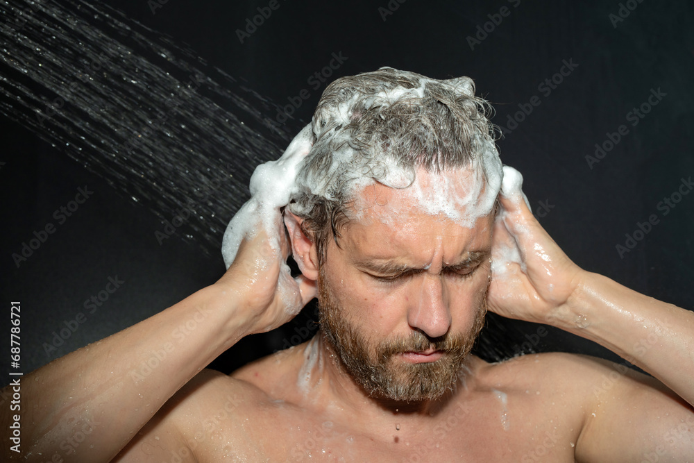 Millennial man washing hair. Guy bathing shower head in bathtub. Face ...