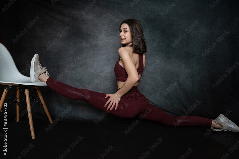 Fitness female trainer demonstrates how to do it right splits in dark ...