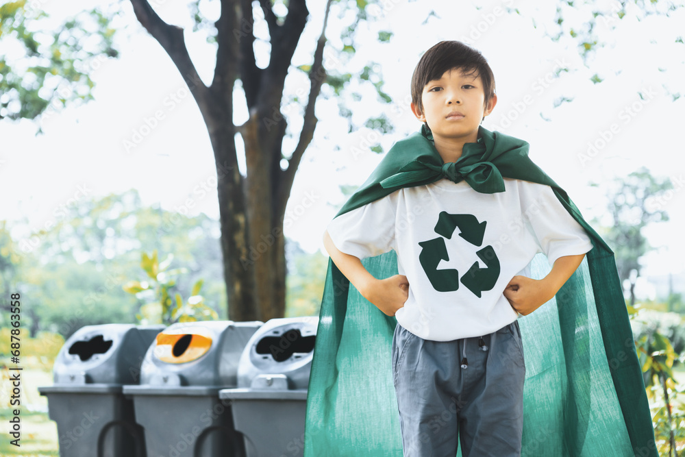 Cheerful young superhero boy with cape and recycle symbol promoting ...