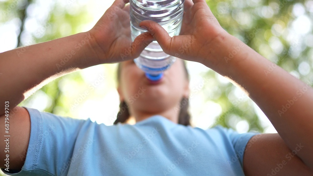 child drinking water from a plastic bottle. lifestyle water shortage problem on earth concept ...