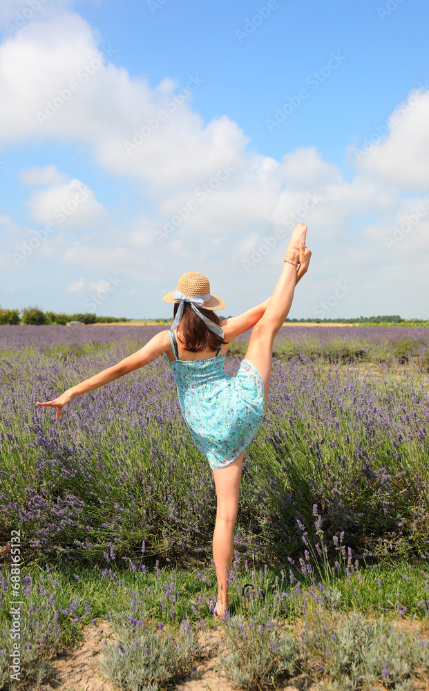 girl performs gymnastic exercises raising her leg well above her head ...