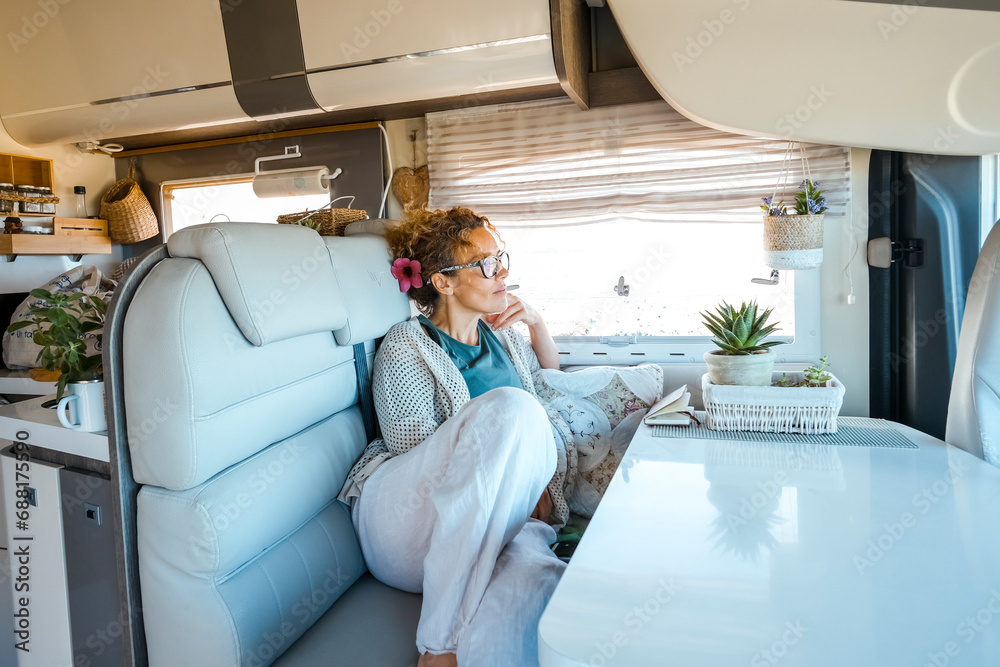 One woman relaxing inside camper van motorhome looking outside the view ...