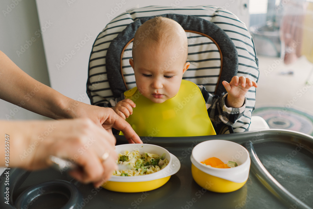Little child with solid nutrition. Baby girl eating finger food and mix ...