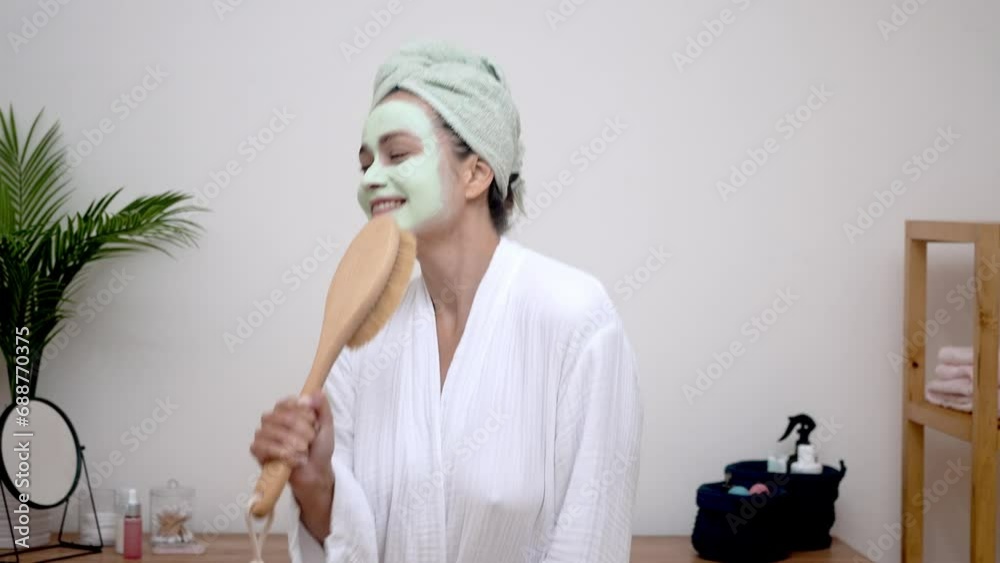Vidéo Stock Home Spa Jam: In her bathrobe, she wears a clay mask, using ...