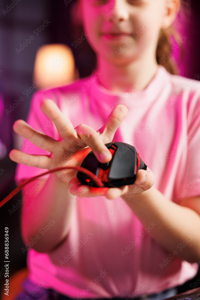 Close up shot of young girl in studio reviewing gaming mouse in front ...