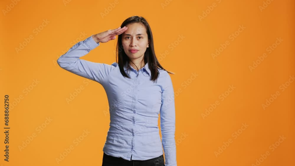 Proud adult presenting military salute symbol in studio, raising arm ...