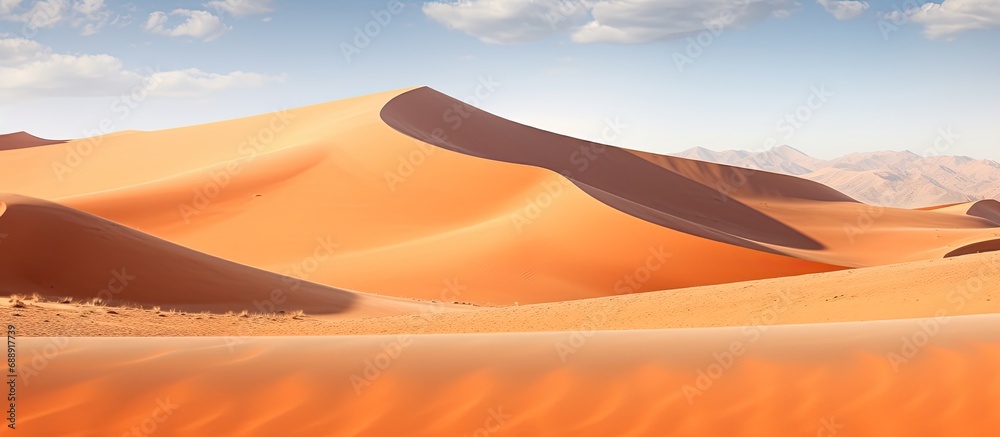 Orange sand dunes and mountains in the Namib desert, Namibia, create a ...
