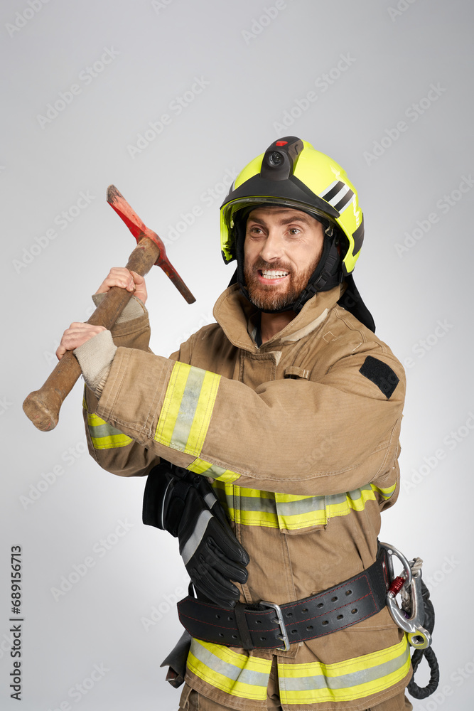 Handsome, brave firefighter battling fire, while using shabby ax ...