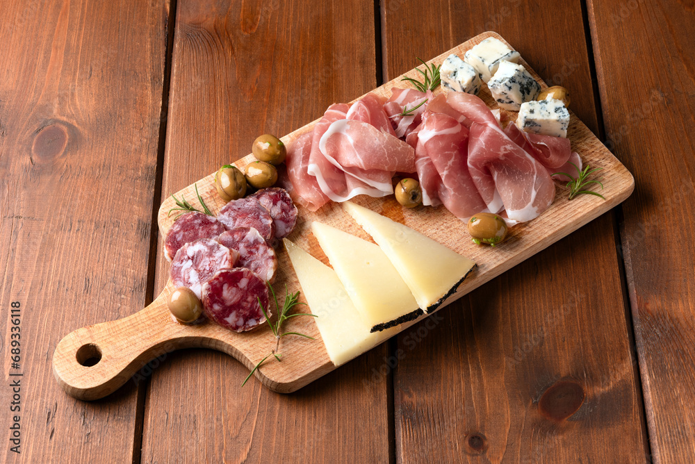 Tagliere con vari antipasti italiani: prosciutto crudo, gorgonzola ...