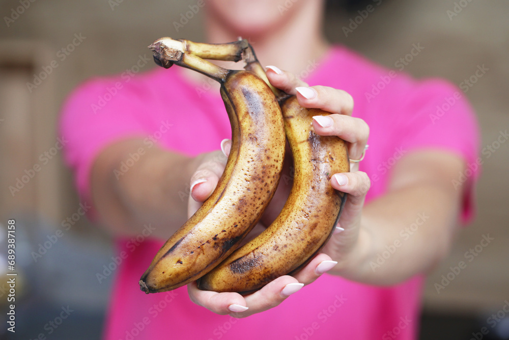 Aging banana background. Woman holding brown ripe bananas. Food waste ...